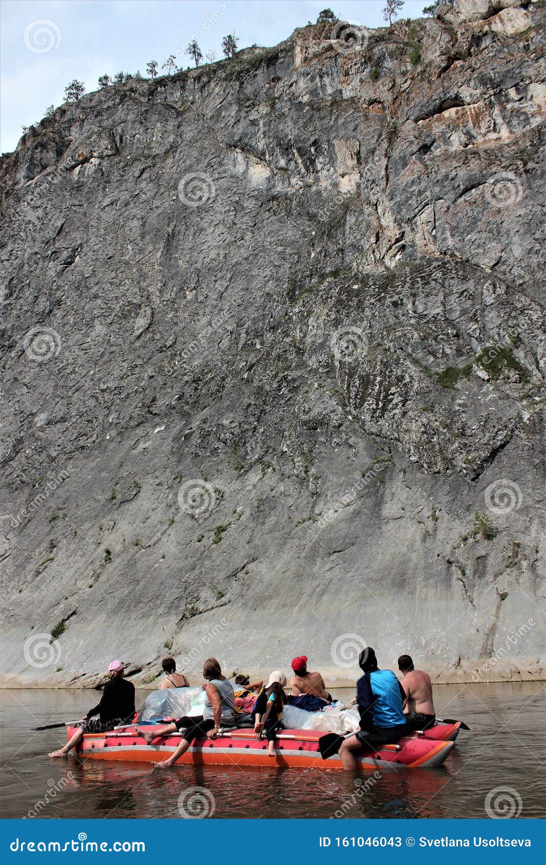 A Team of People Floating on the River in an Inflatable Catamaran among ...