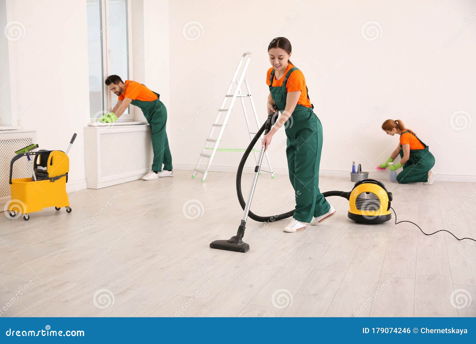 Team of Janitors in Uniforms Cleaning Room Stock Photo - Image of cart ...