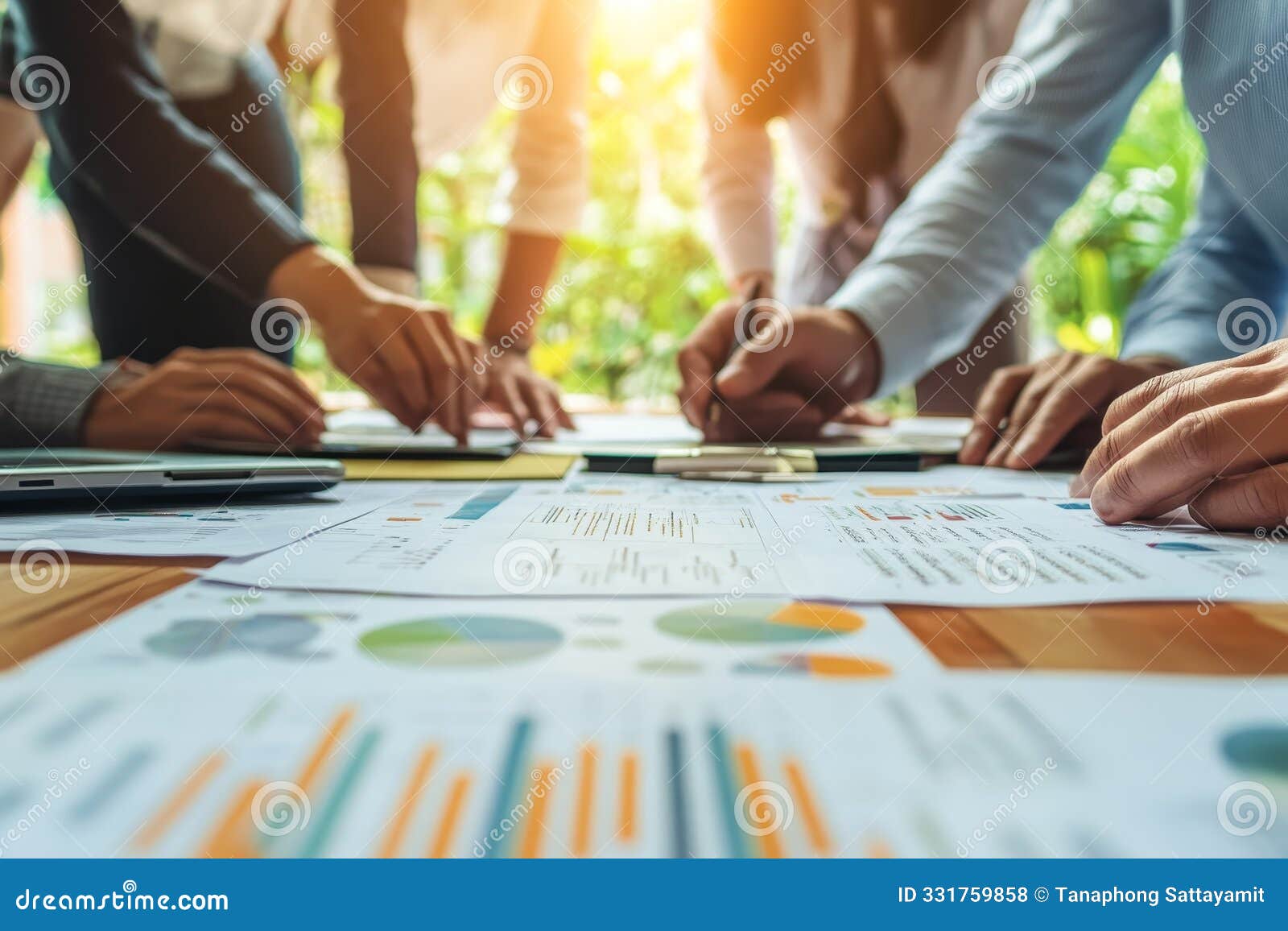 A Team of Professionals Gathered Around a Table Analyzing Data and ...