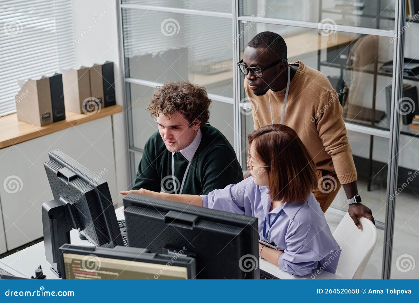 Team Of Programmers Talking About Algorithm Running On Laptop Screen Pointing At Source Code