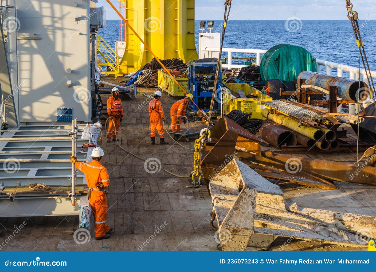A Team of Rigger Lifting an Anchor from a Construction Work Barge ...