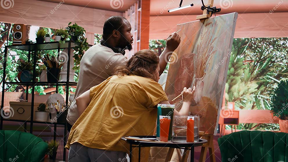 Team of Skilled Artists Collaborating on Rustic Painting in Art Studio ...