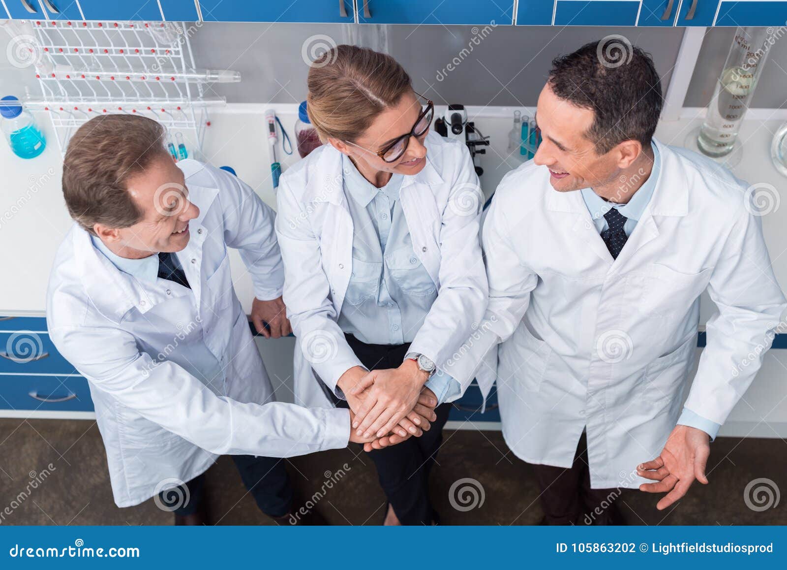 Scientists holding hands stock photo. Image of smile - 105863202