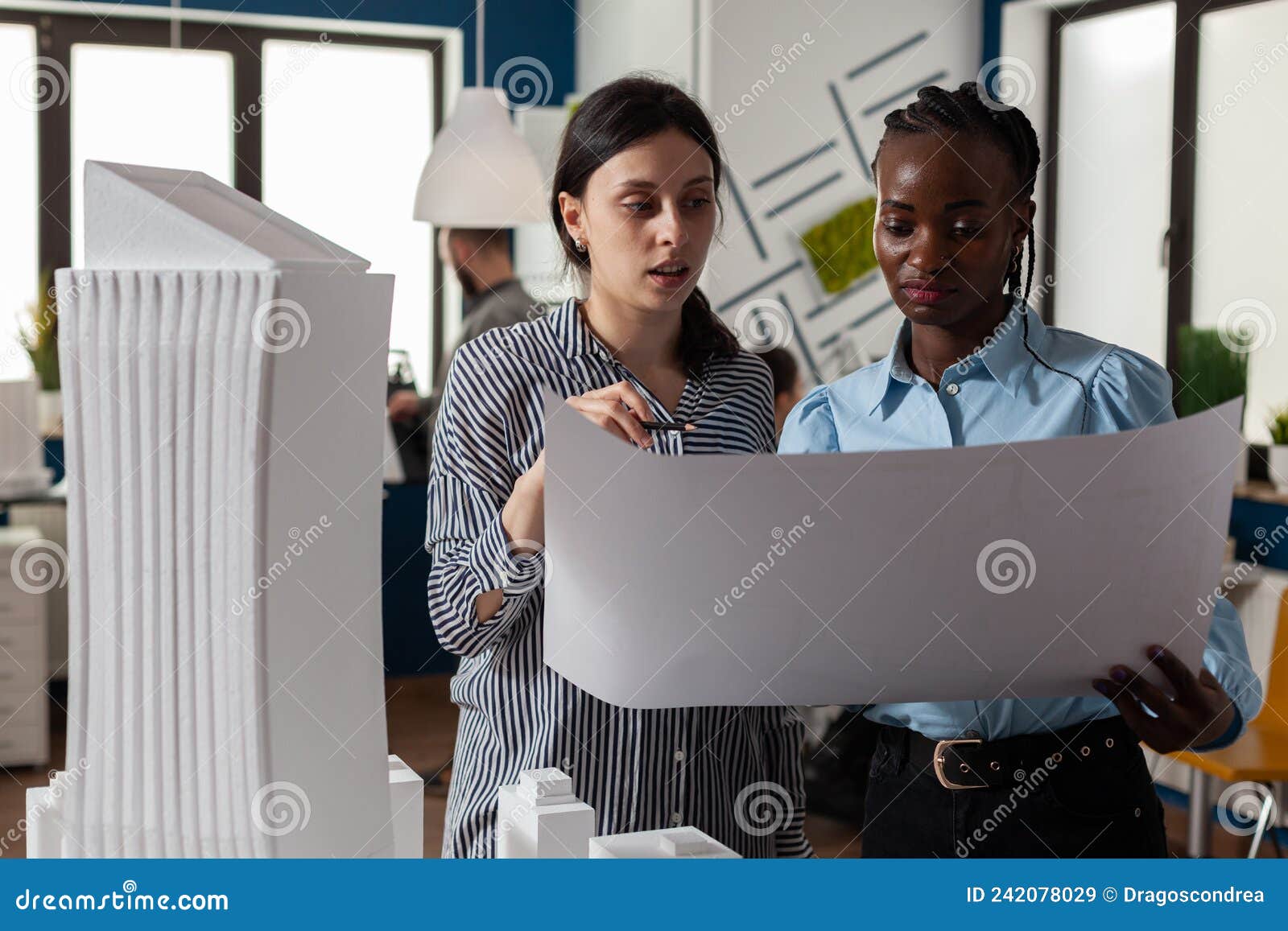 Team of Two Women Architects Reading Architectural Blueprints Stock ...
