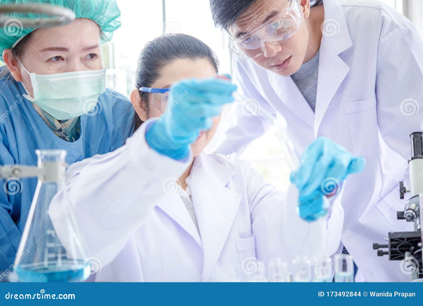 Scientists Analyzing Study Data And Evaluating Microscope. Health Care ...