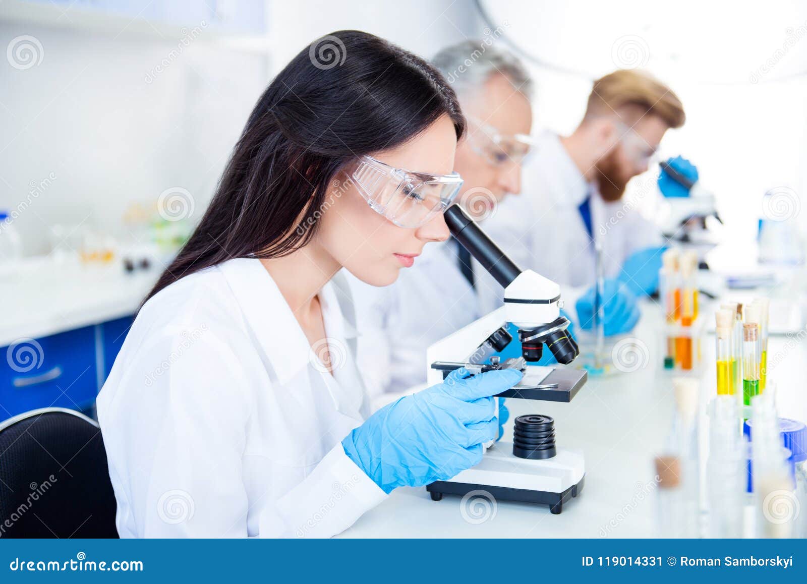 Team Work. Young Brunette Lab Worker in Protective Glasses is an Stock ...