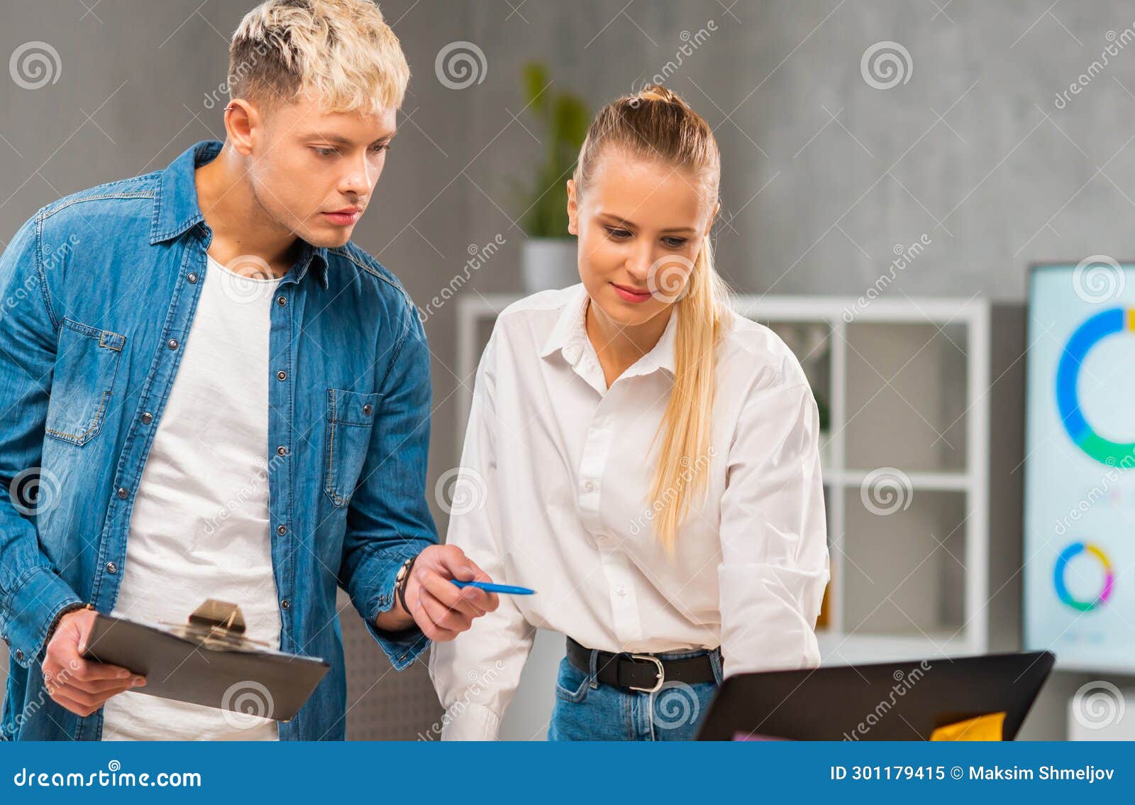 Team of Young and Confident Startupers is Working at the Table in the Office, Discussing the ...