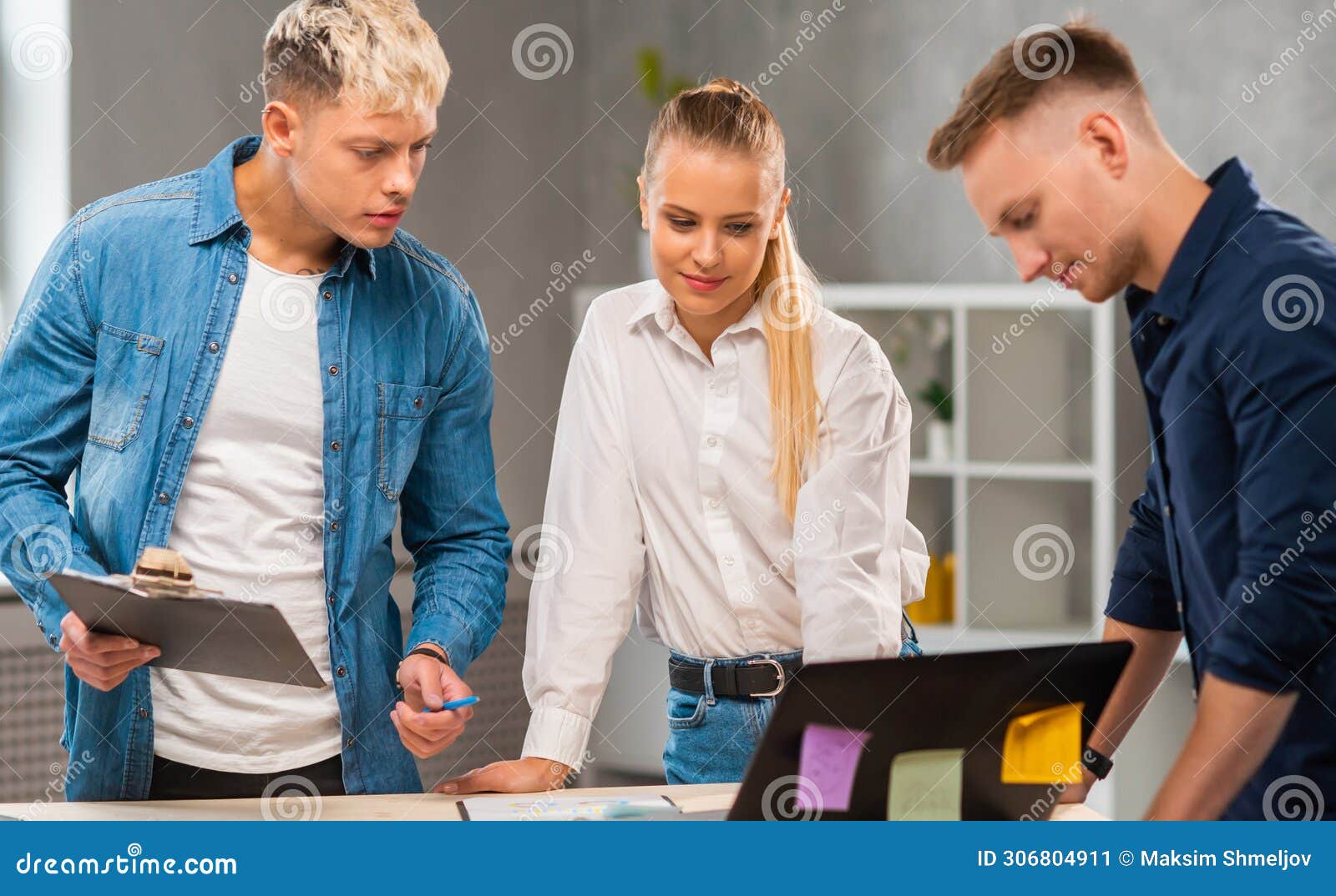 Team of Young and Confident Startupers is Working at the Table in the Office, Discussing the ...