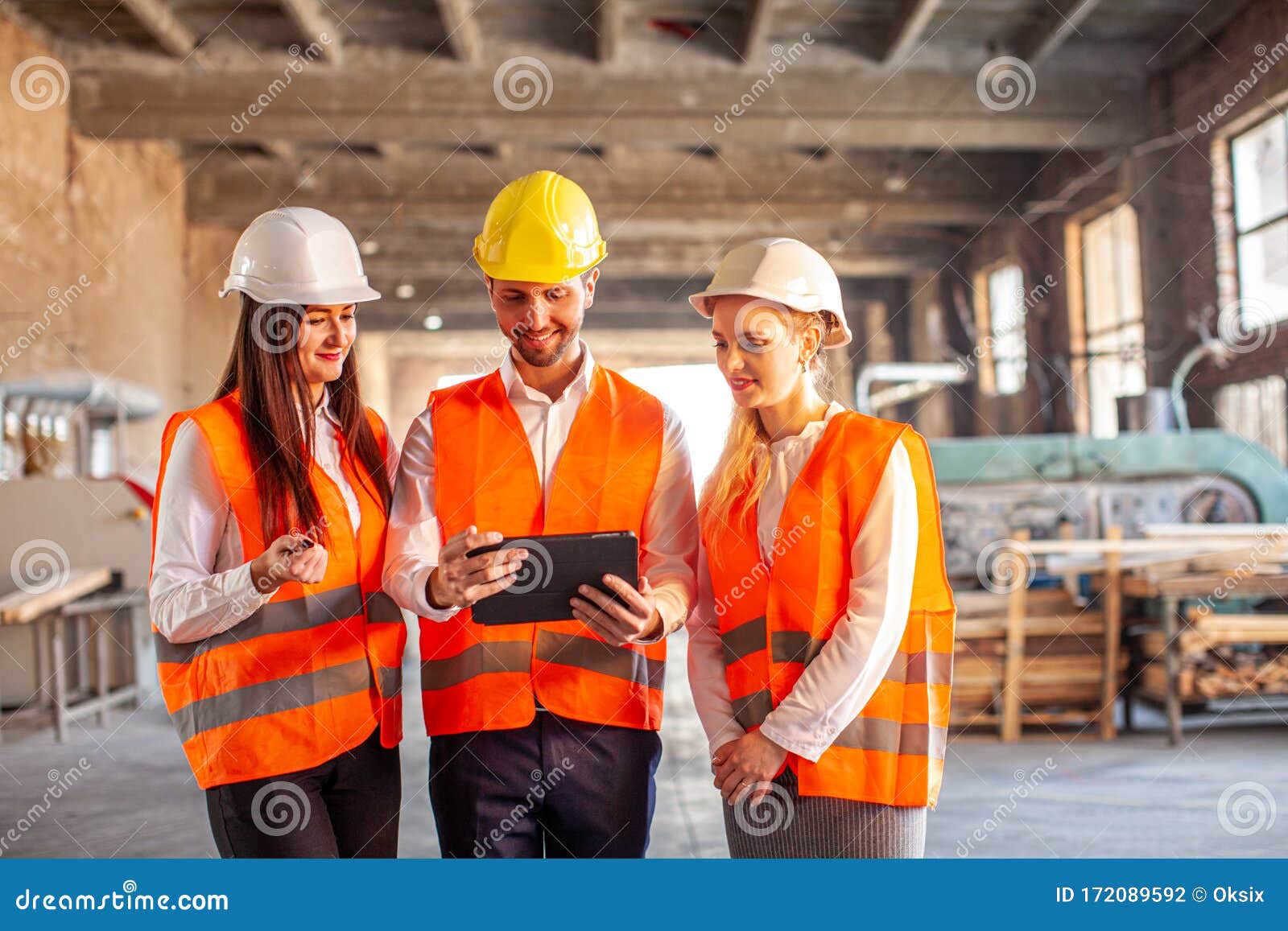 Team of Young Construction Workers Discussing Project Details with ...