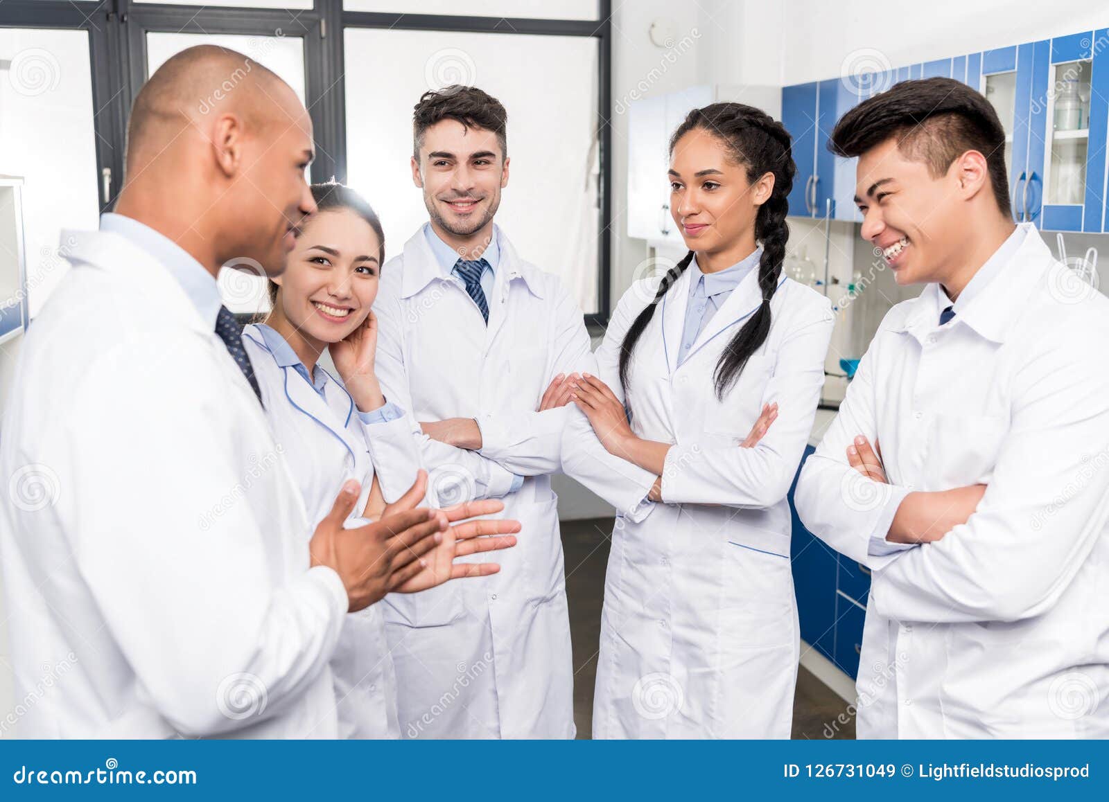Team of Young Doctors in Lab Coats Discussing Work Stock Image - Image ...