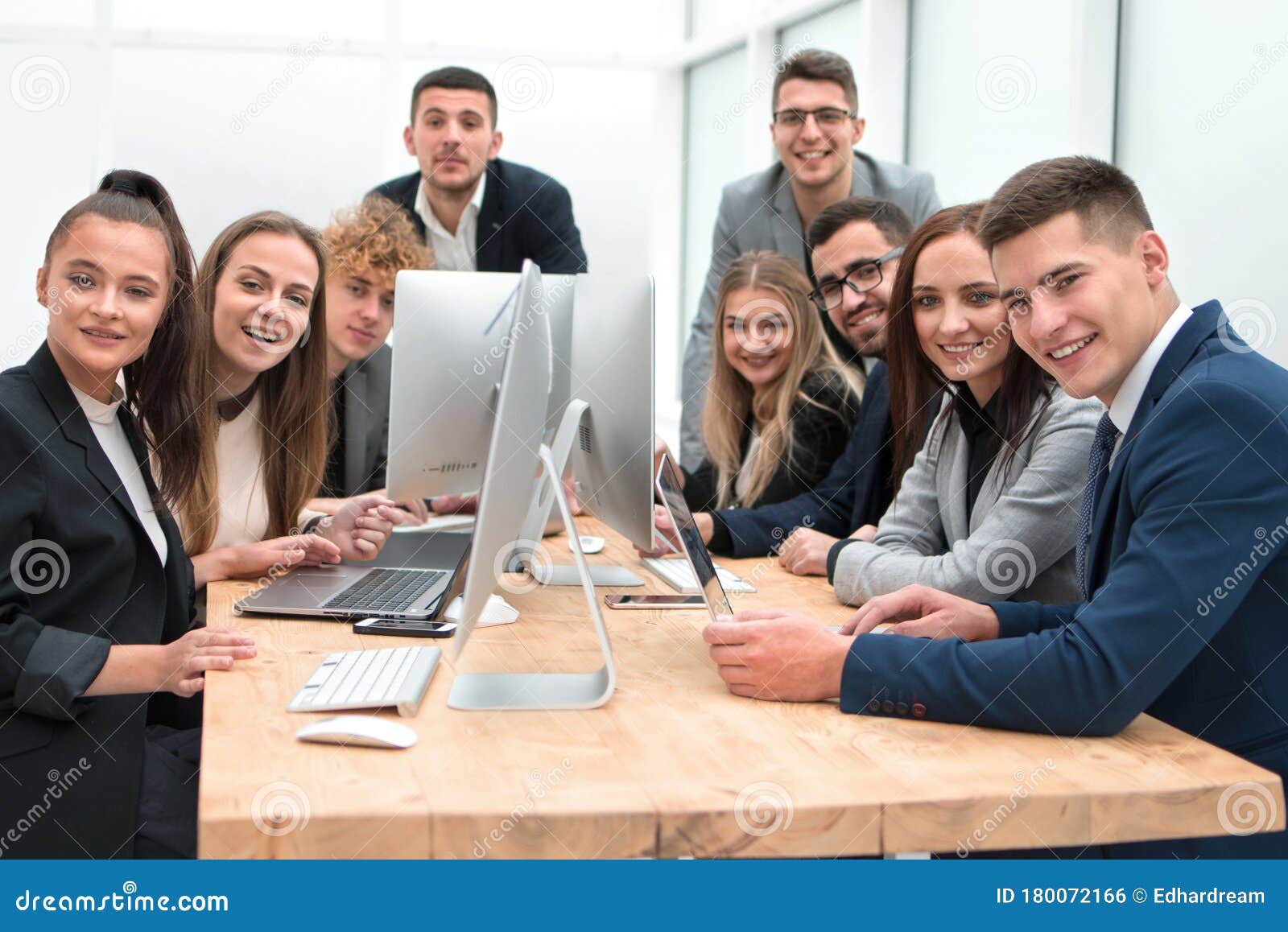 Team of Young Professionals Sitting at an Office Desk Stock Photo ...
