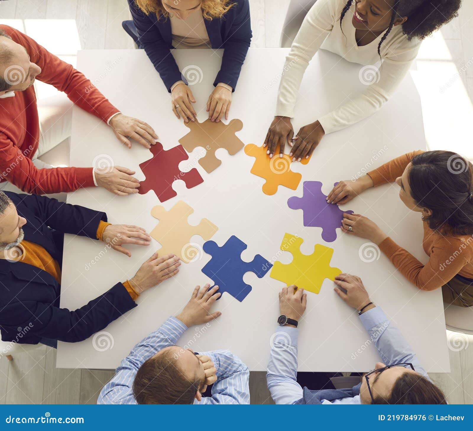 Business Team Sitting Around Office Table and Putting Jigsaw Puzzle ... Business Team Sitting Around Office Table and Putting Jigsaw Puzzle ...