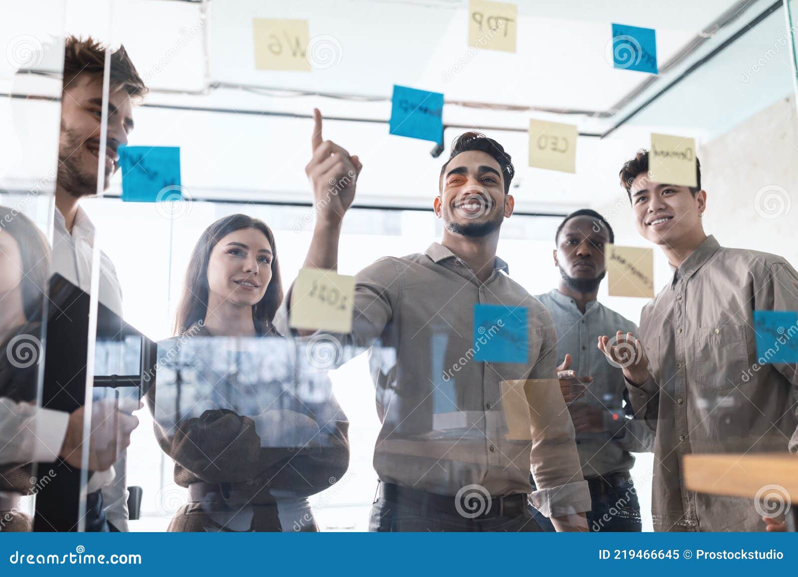 Colleagues Having Meeting Using Sticky Post-it Notes on Glass Wall ...