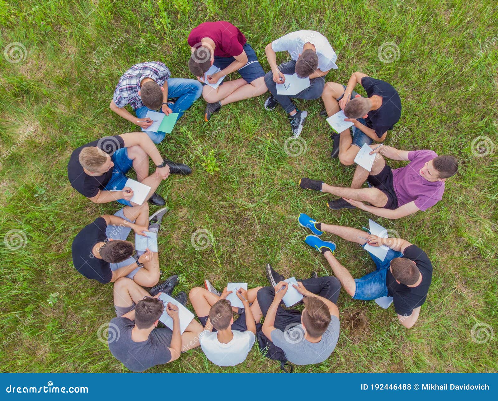 Teamwork Concept. a Group of High School Students Sit on the Grass in a ...