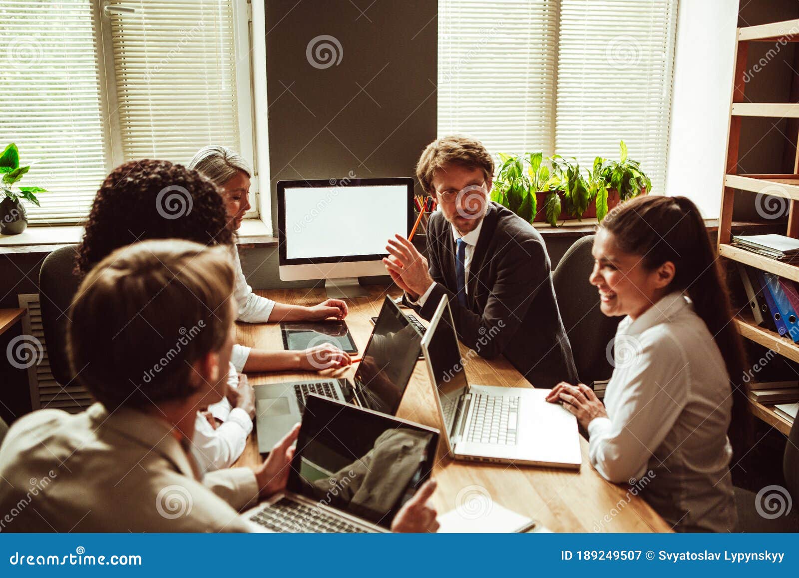 Teamwork of Diverse Group Sitting at Negotiation Table with Computers ...