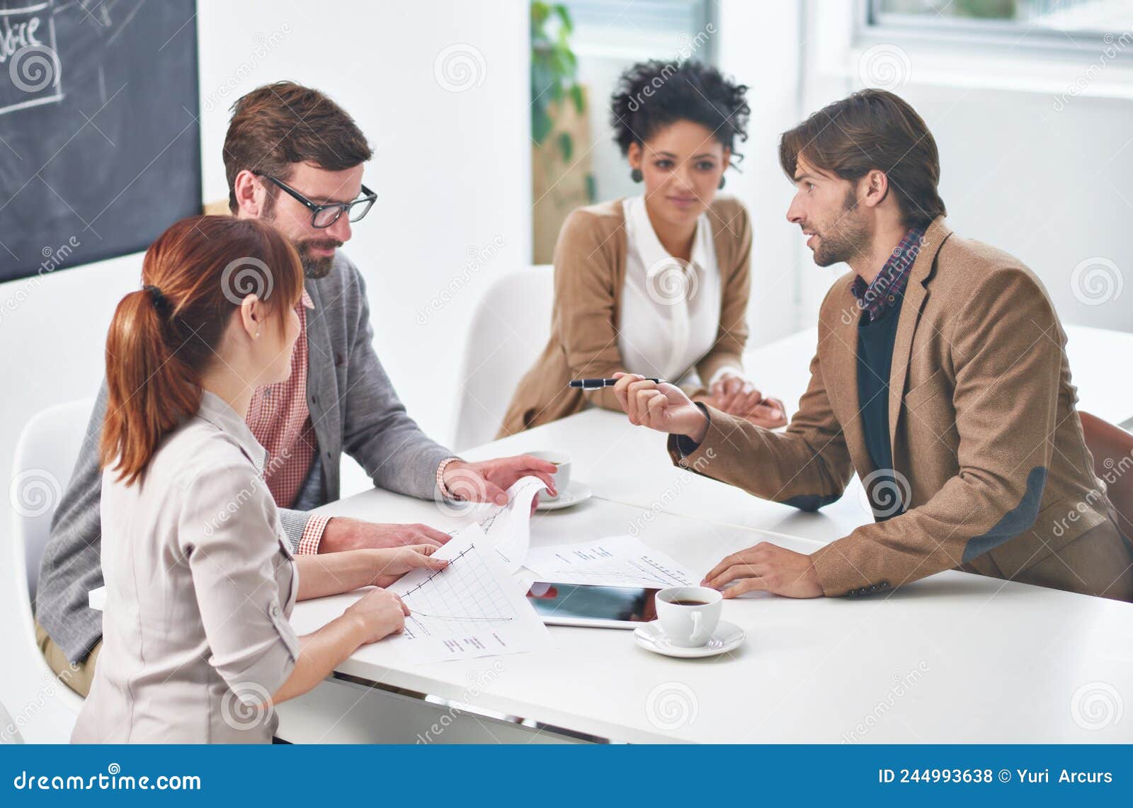 Teamwork Gets Business Done. a Group of Businesspeople Going Over Some ...