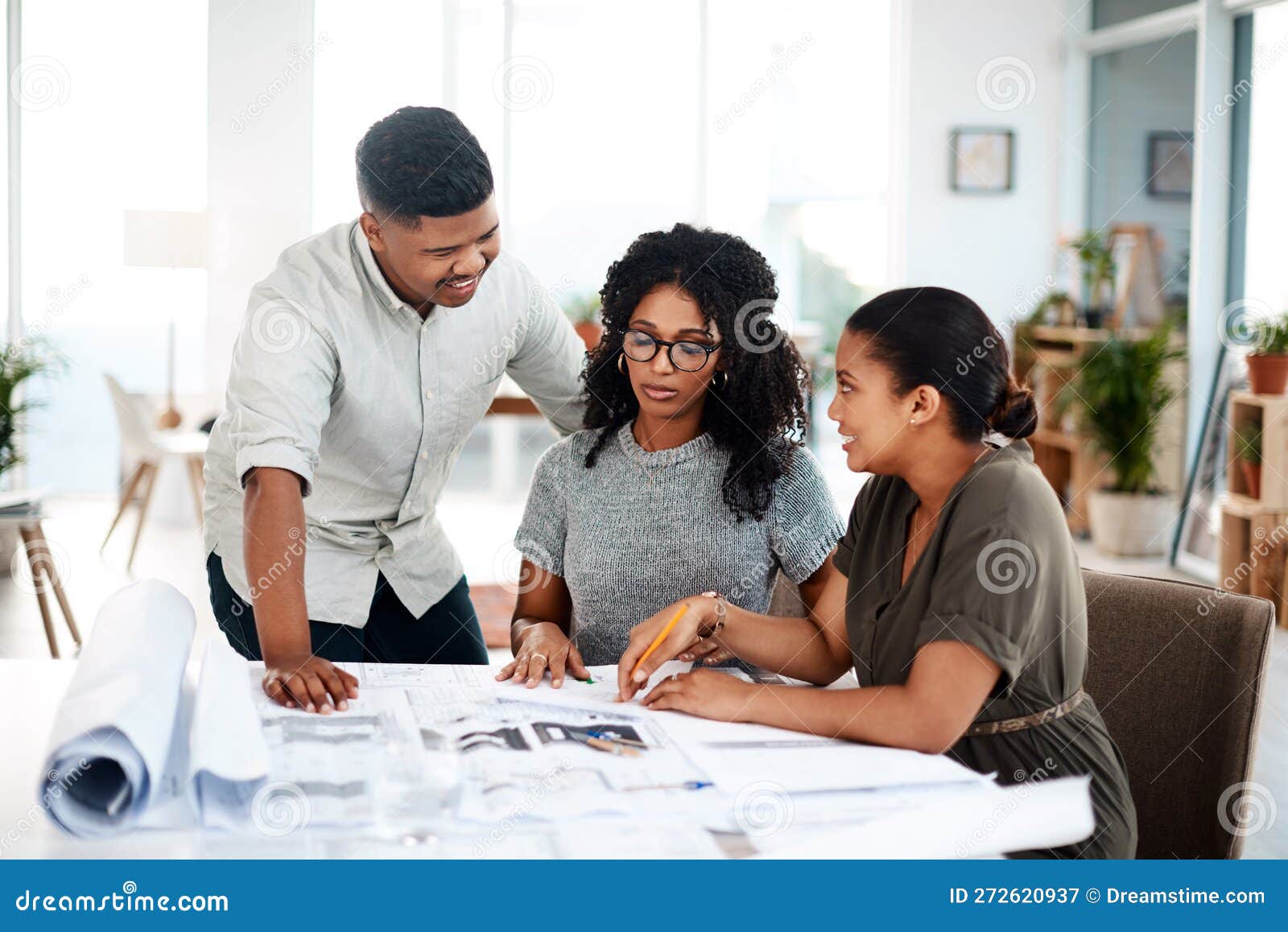 Teamwork Makes the Blueprint Work. a Group of Young Businesspeople ...