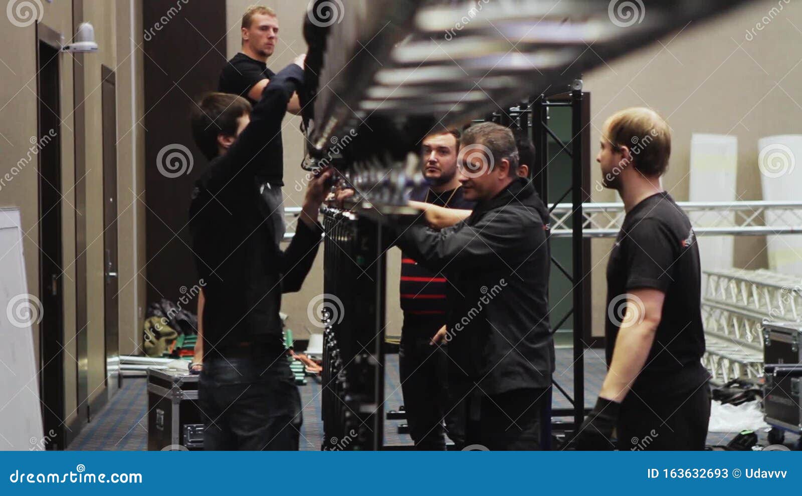 Group of Male Workers are Installing Parts of Big Screen To Aluminium ...