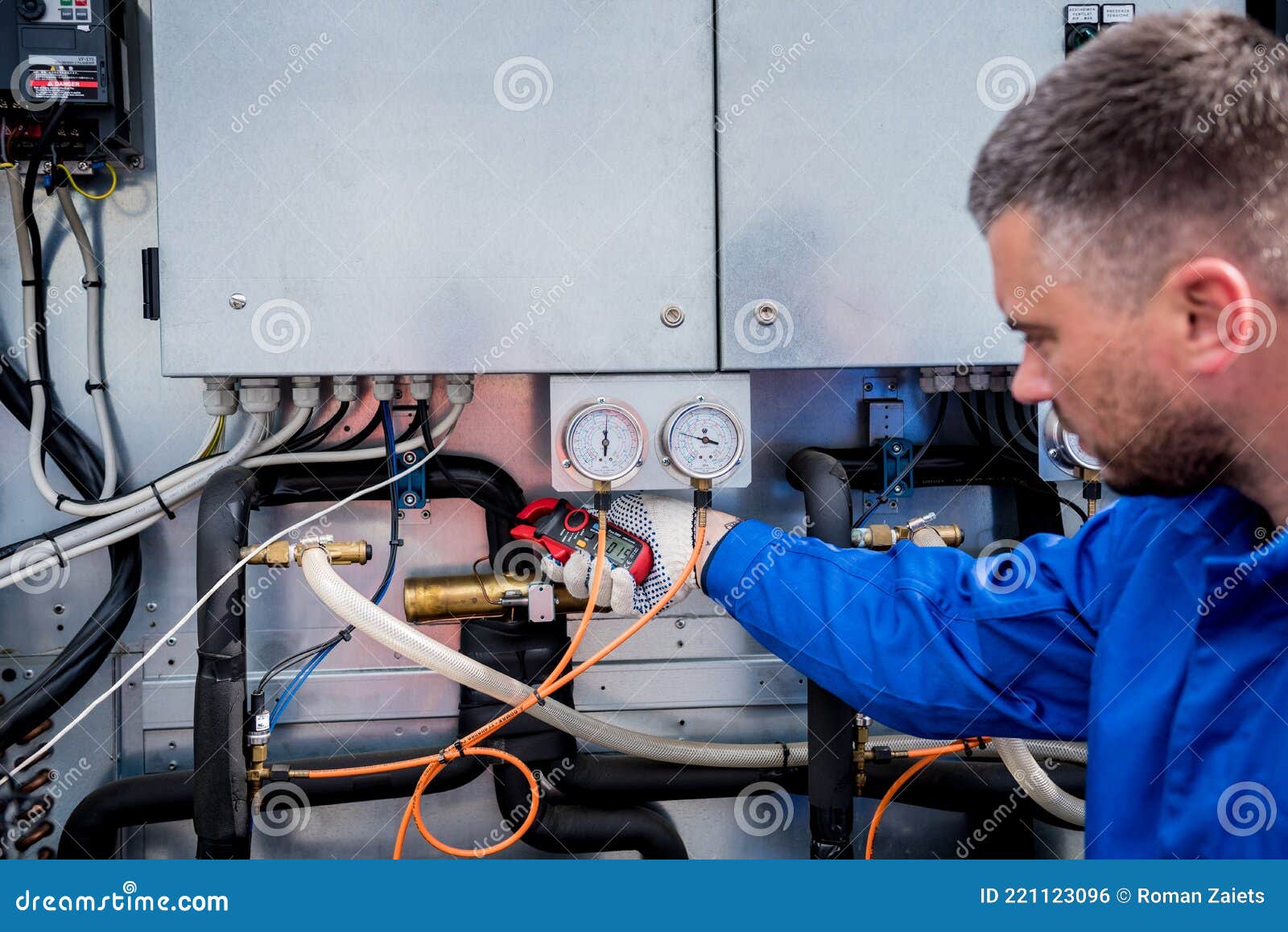 The Technician Checking Power Lines of the Heat Exchanger with Current ...