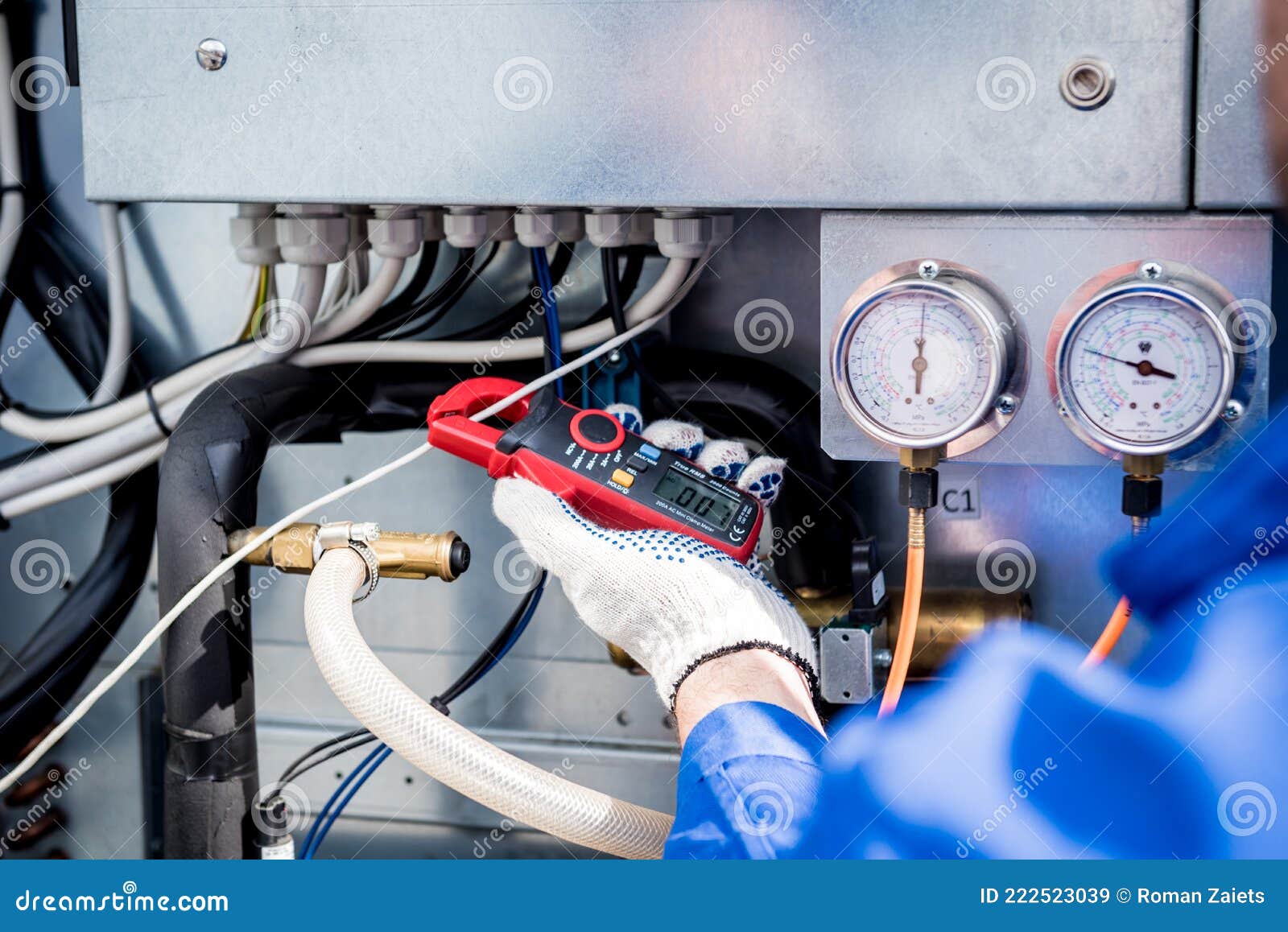 The Technician Checking Power Lines of the Heat Exchanger with Current ...