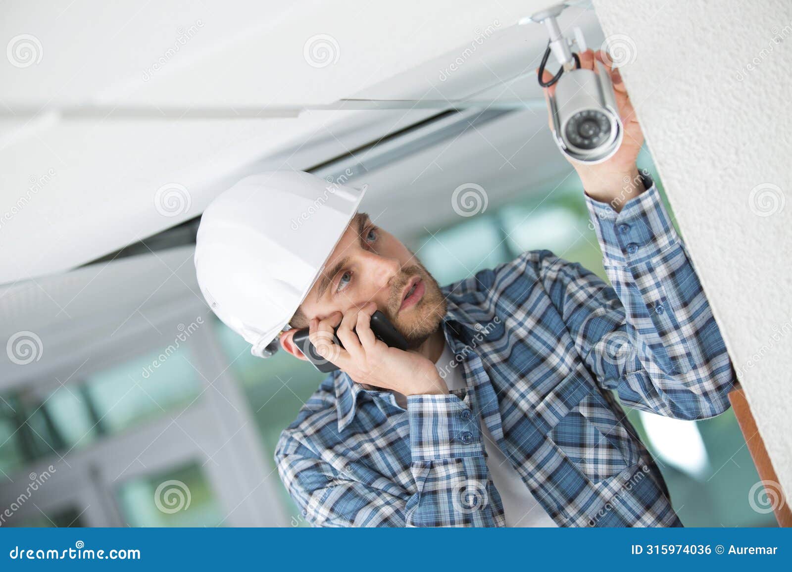 Technician Fixing Cctv Camera on Wall and Phoning for Help Stock Photo ...