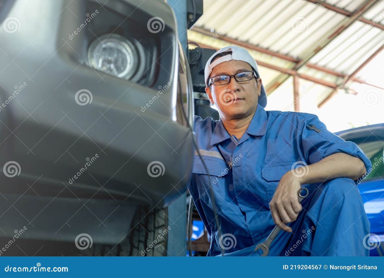 Technician or Garage Worker Sit beside of Car and Look at Camera during ...