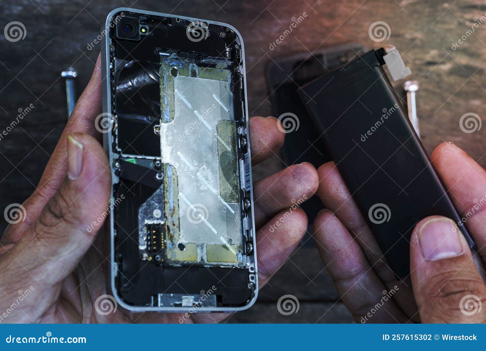 Technician Holding an Open Mobile Phone and Showing the Inside of it ...