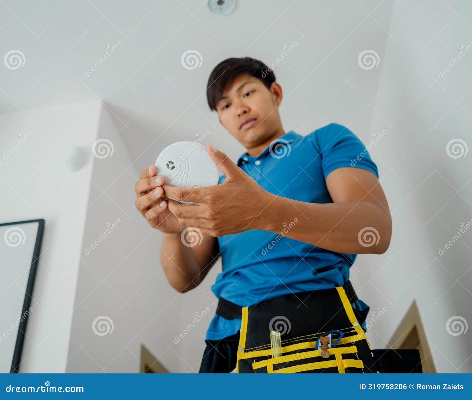 Technician Installing Fire Safety Detector in a Modern Apartment Stock ...