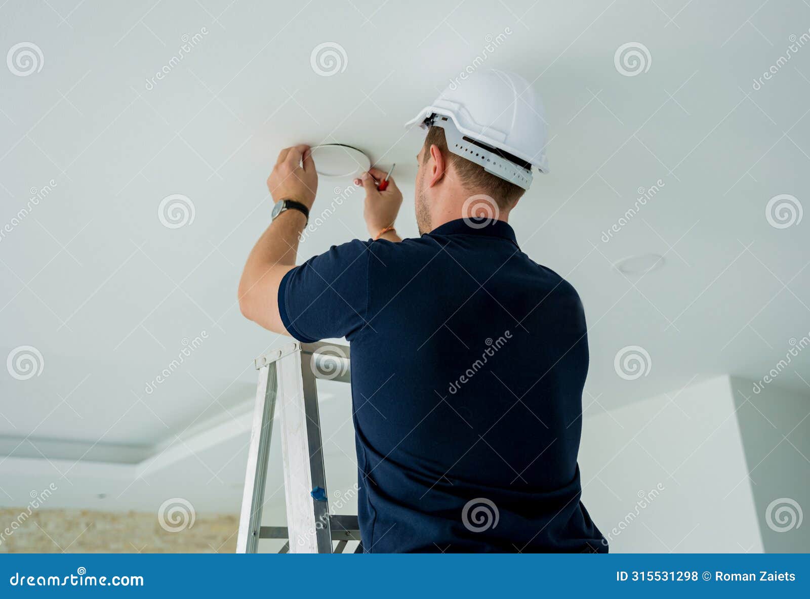 Technician is Installing an LED Spotlight in the Ceiling. Stock Photo ...