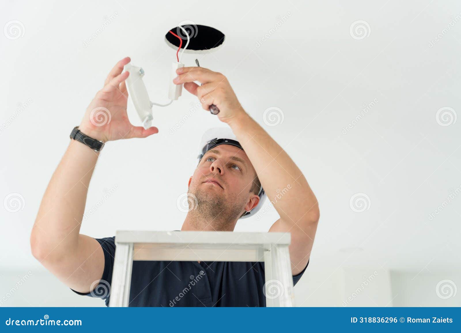 Technician is Installing an LED Spotlight in the Ceiling. Stock Photo ...