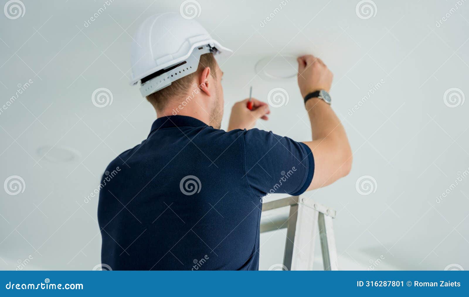 Technician is Installing an LED Spotlight in the Ceiling. Stock Image ...