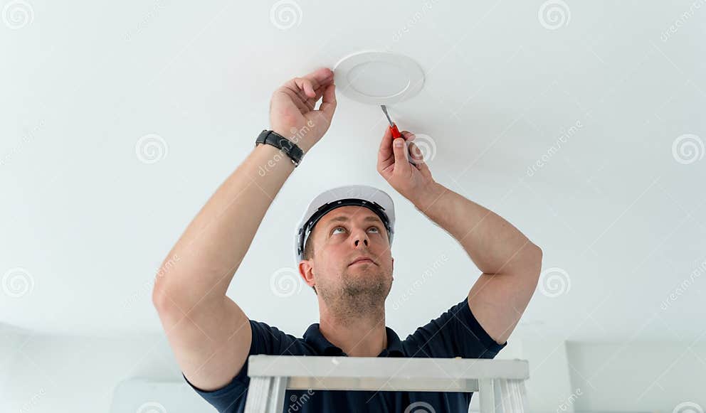 Technician is Installing an LED Spotlight in the Ceiling. Stock Photo ...