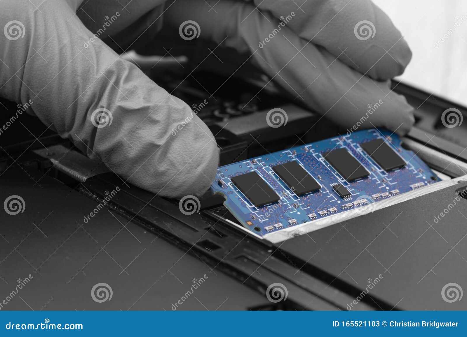 Technician Installing RAM into the Memory Slot on a Laptop Computer ...