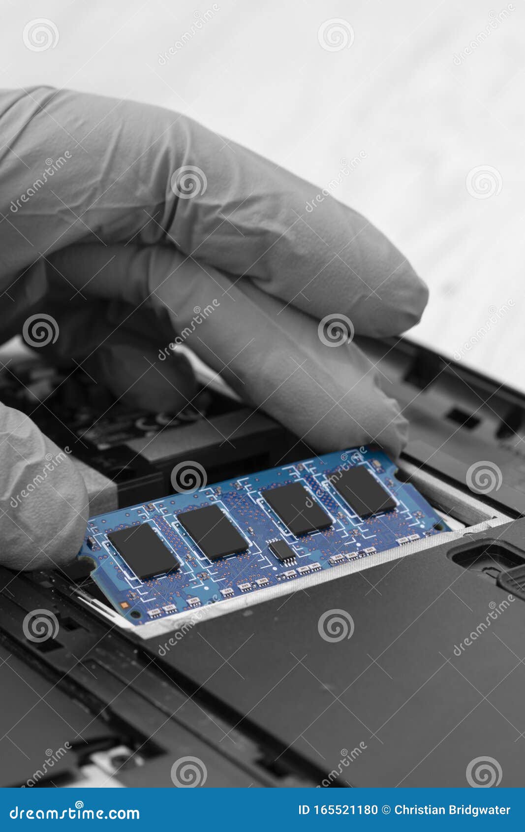 Technician Installing RAM into the Memory Slot on a Laptop Computer ...