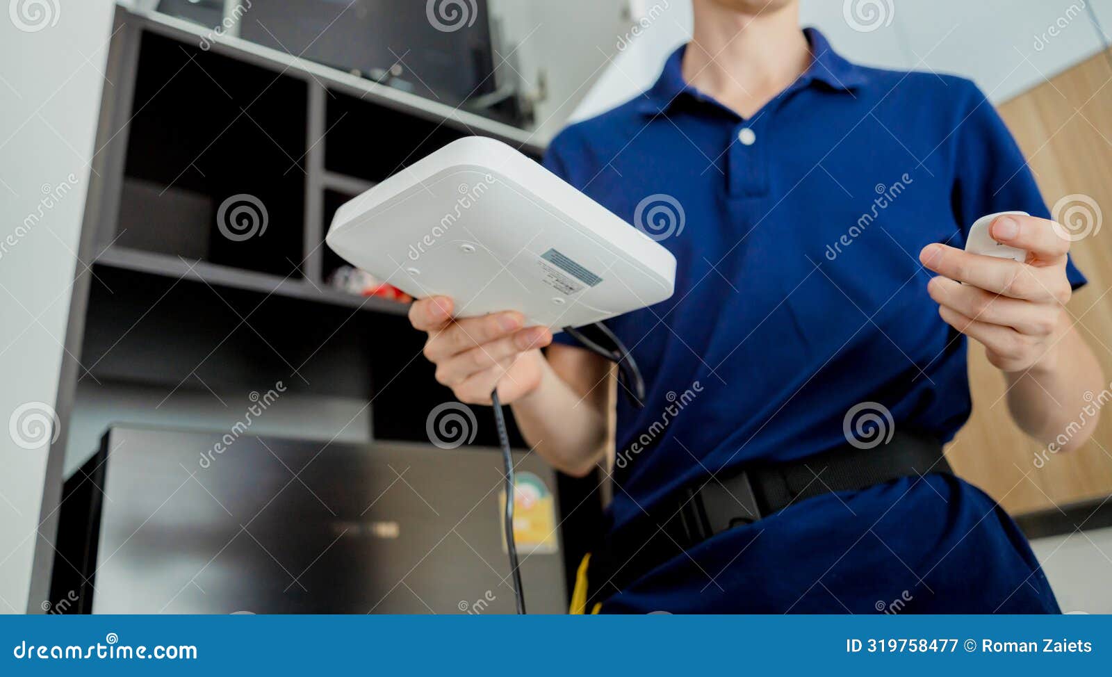 A Technician Installs a Main Unit Security System in a Modern Apartment ...