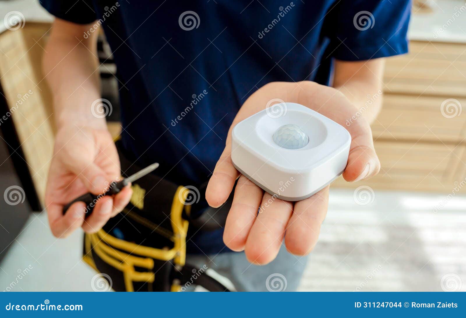 A Technician Installs a Modern Movement Detector in a Cozy Apartment ...