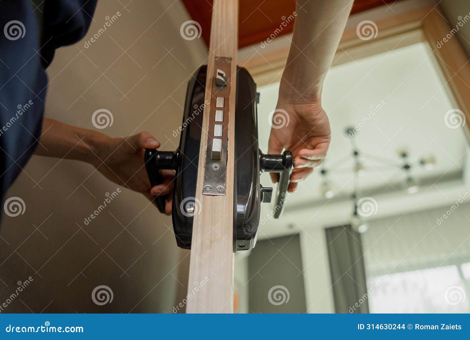 A Technician Installs a Modern Smart Door Lock on the Wood Door Stock ...
