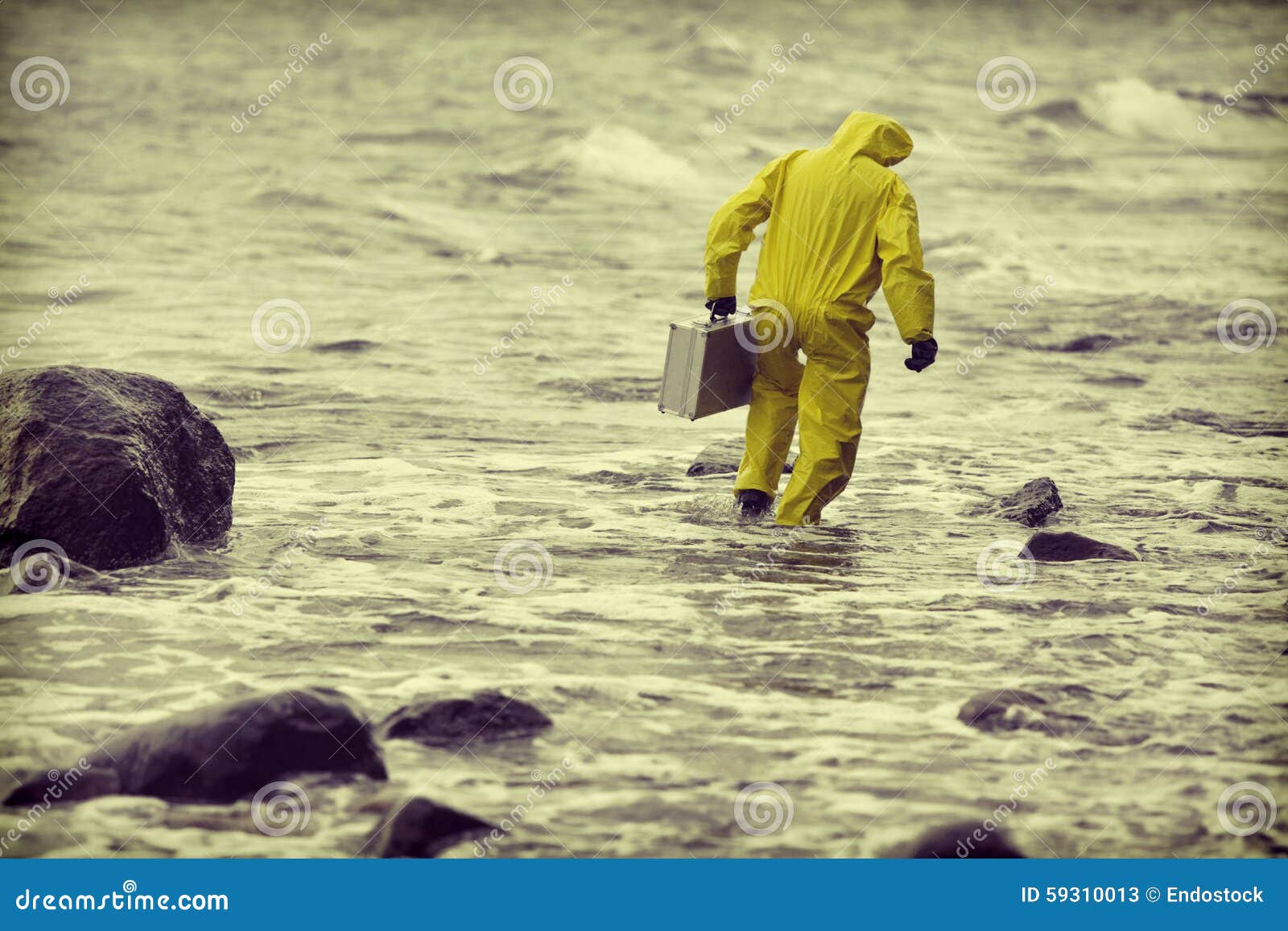Technician in Protective Suit Walking in Water at Rocky Beach Stock ...