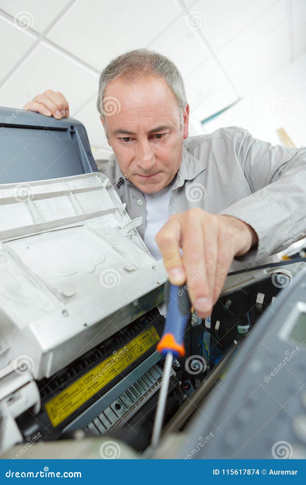 Technician Reaching into Appliance with Screwdriver Stock Photo - Image ...