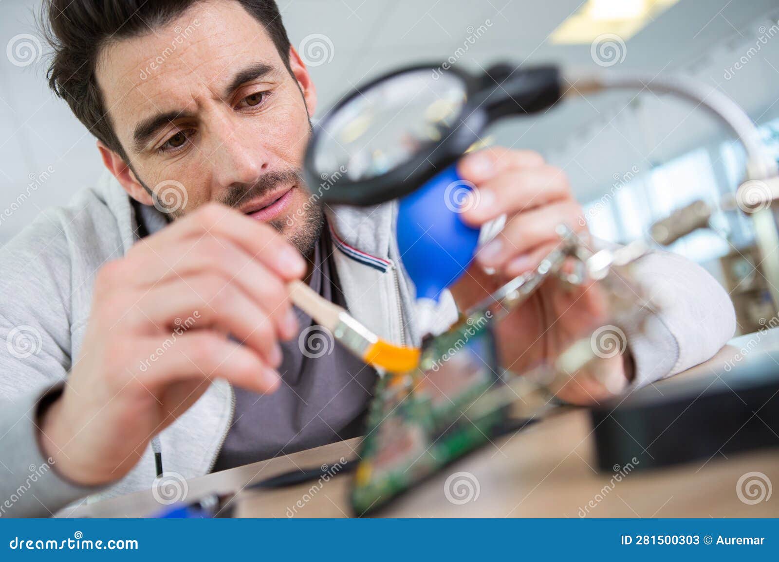 Technician Repairing Electronics Components through Magnifying Glass ...