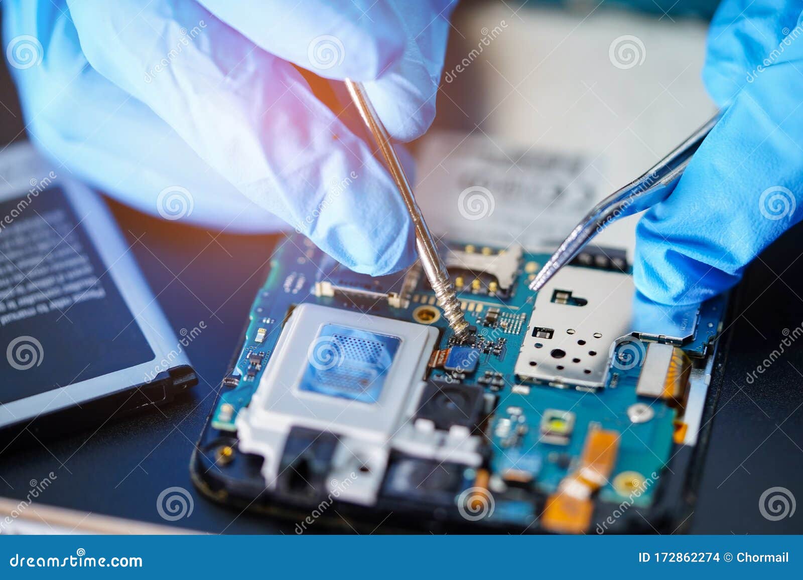 Technician Repairing Micro Circuit Main Board of Smartphone Electronic ...