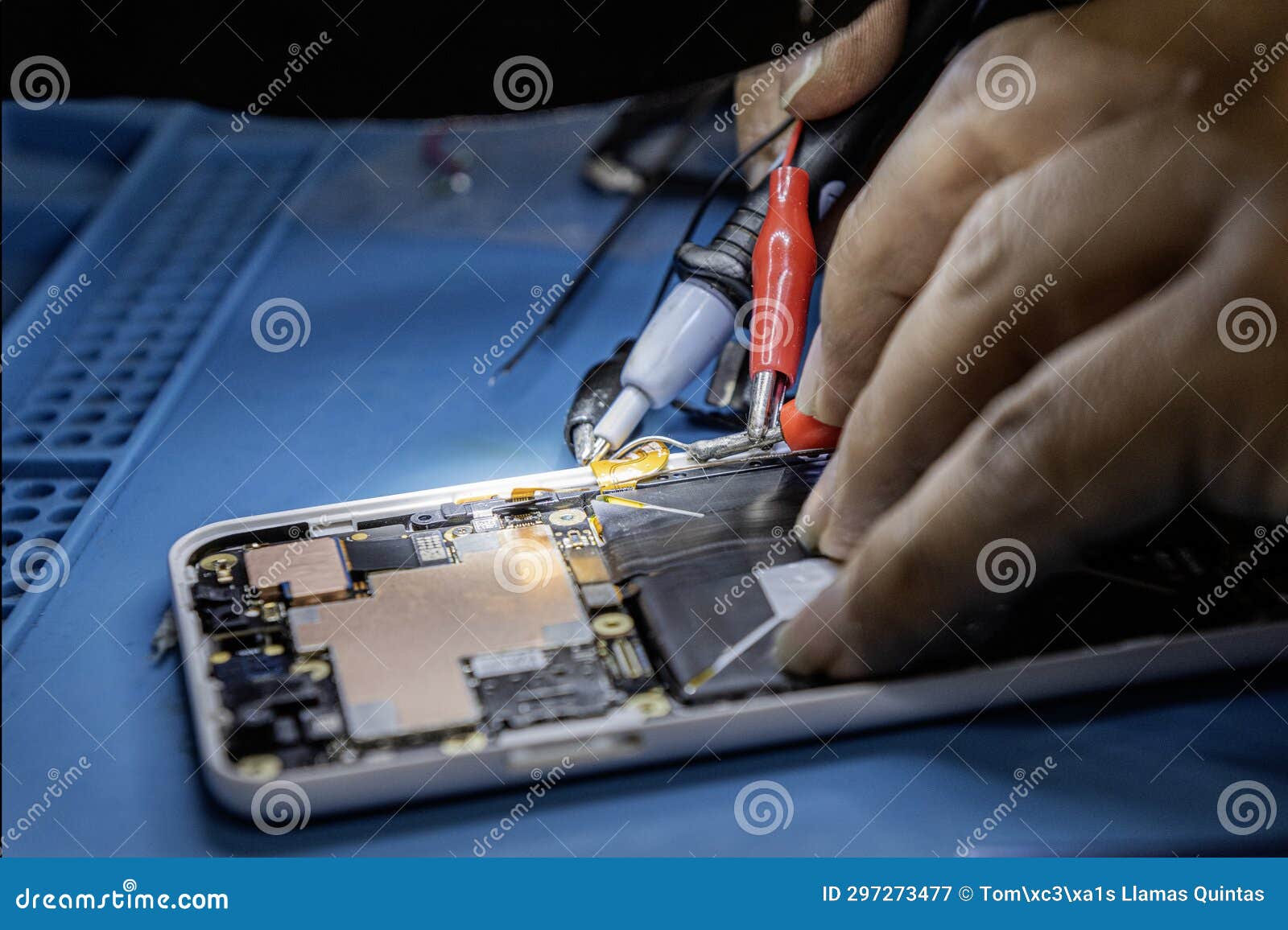 A Technician Repairing a Mobile Phone on His Blue Antielectromagnetic ...