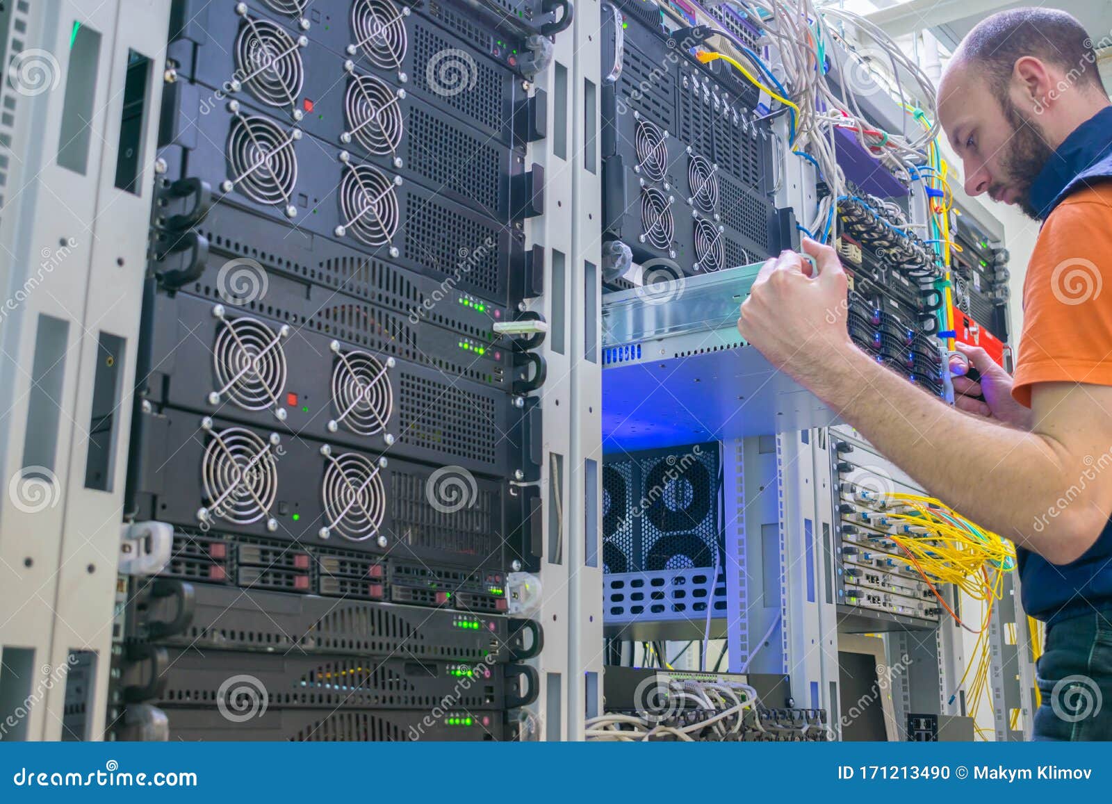 A Technician Repairs the Central Router. a Man Works in a Server Room ...