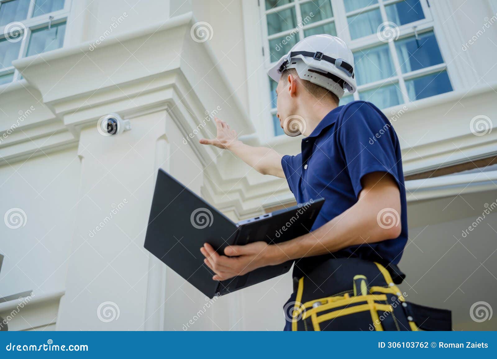 A Technician Sets Up a CCTV Camera on the Facade of a Residential ...