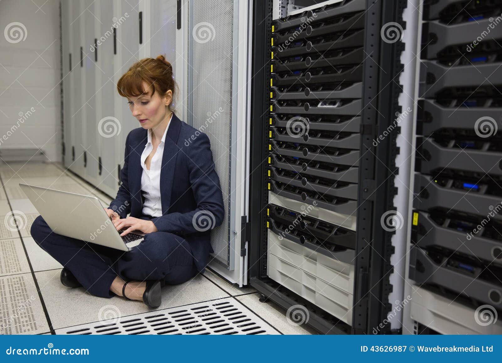 Technician Sitting on Floor beside Server Tower Using Laptop Stock ...