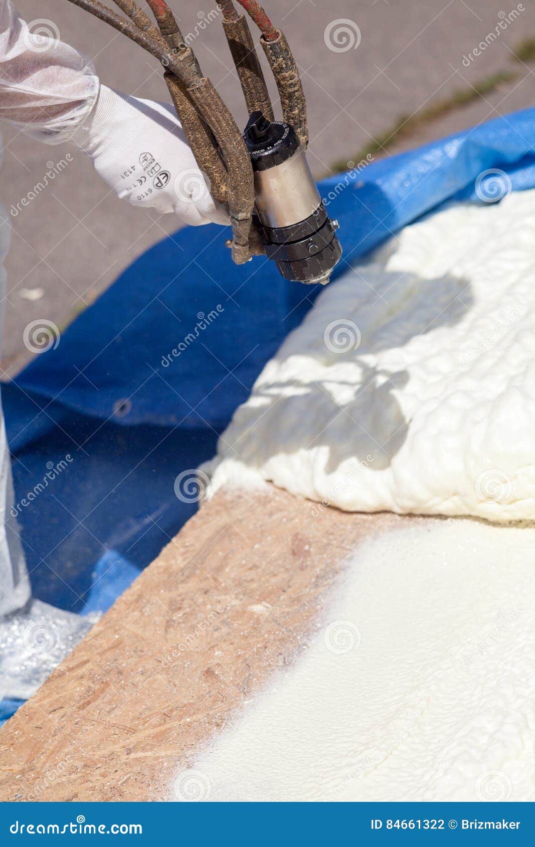Technician Spraying Blown Fiberglass Insulation Between Attic Trusses ...