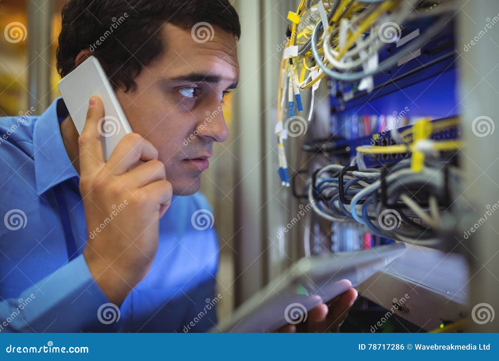 Technician Talking on Mobile Phone while Analyzing Server Stock Photo ...