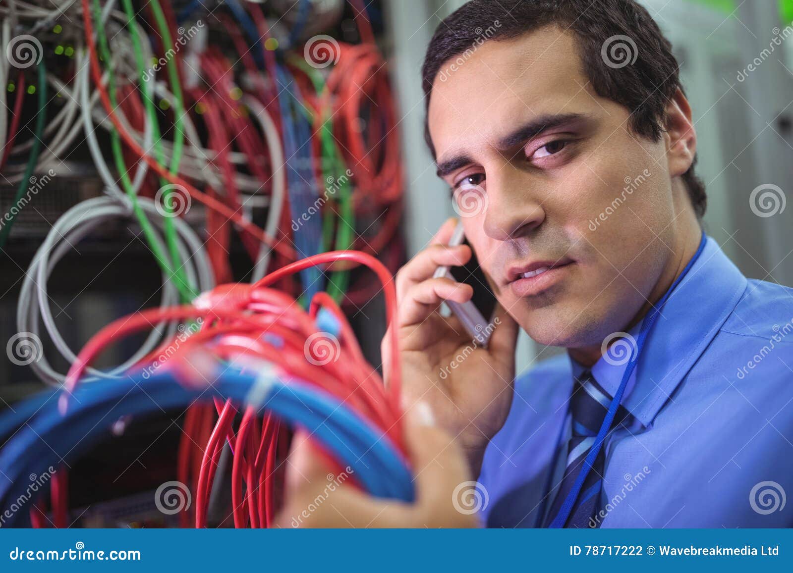 Technician Talking on Mobile Phone while Checking Cables Stock Photo ...