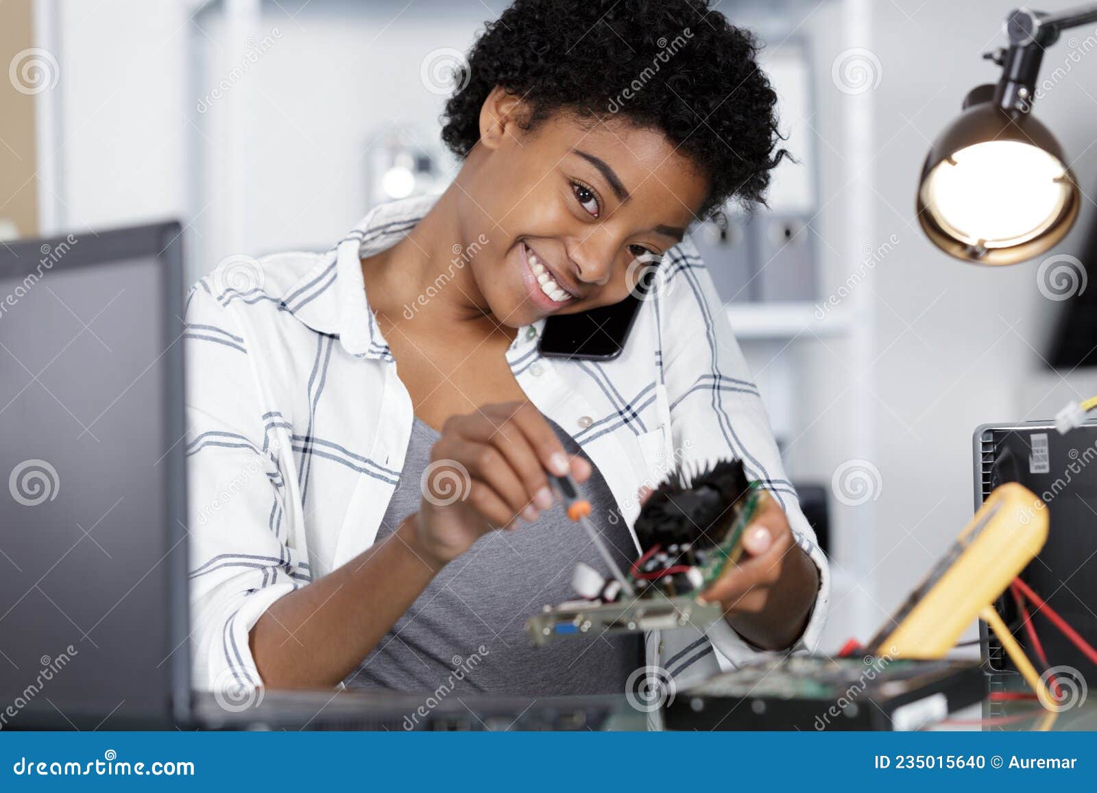 Technician Talking on Mobile Phone while Repairing Electronics Stock ...