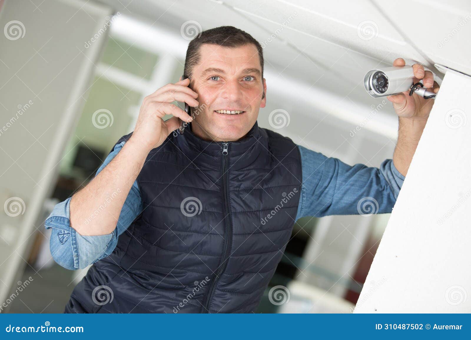 Technician Talking by Phone Installing Security Camera Stock Photo ...